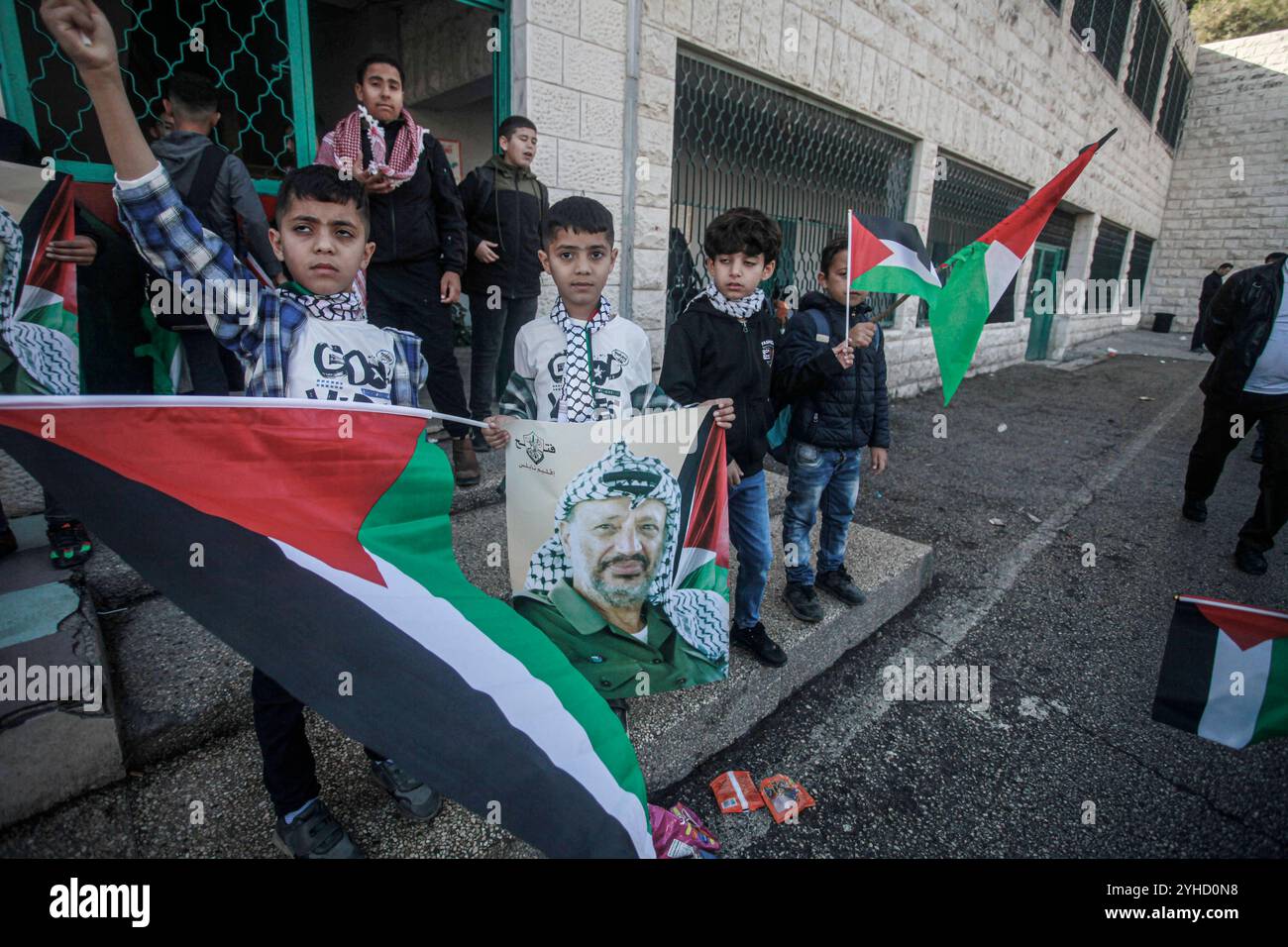 Palestinian school students wave Palestinian flags and pictures of late ...