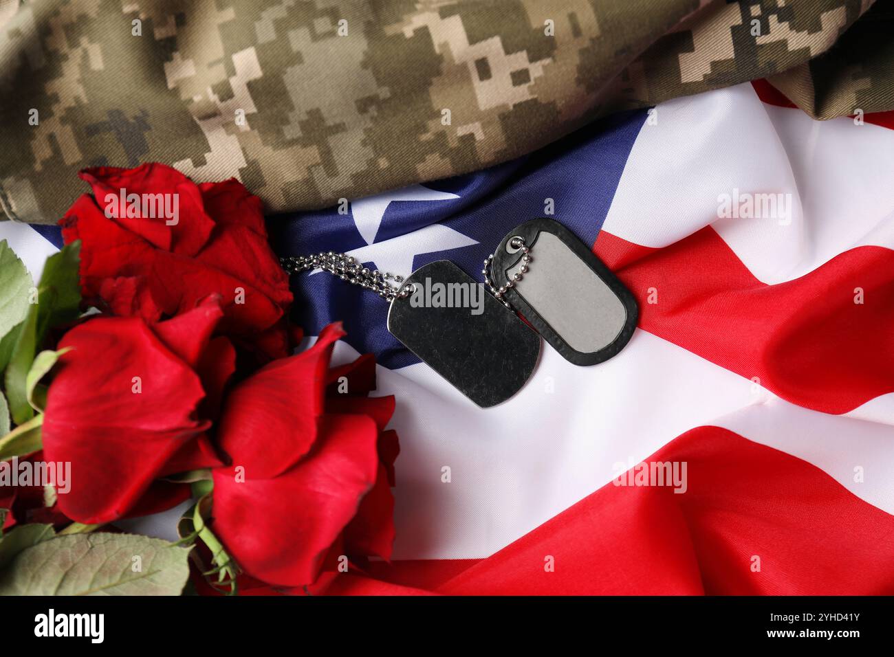 Veterans day. Army tokens, roses and military uniform on American flag ...