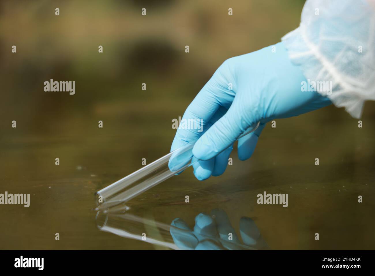 Examination of water quality. Researcher taking water sample from lake ...