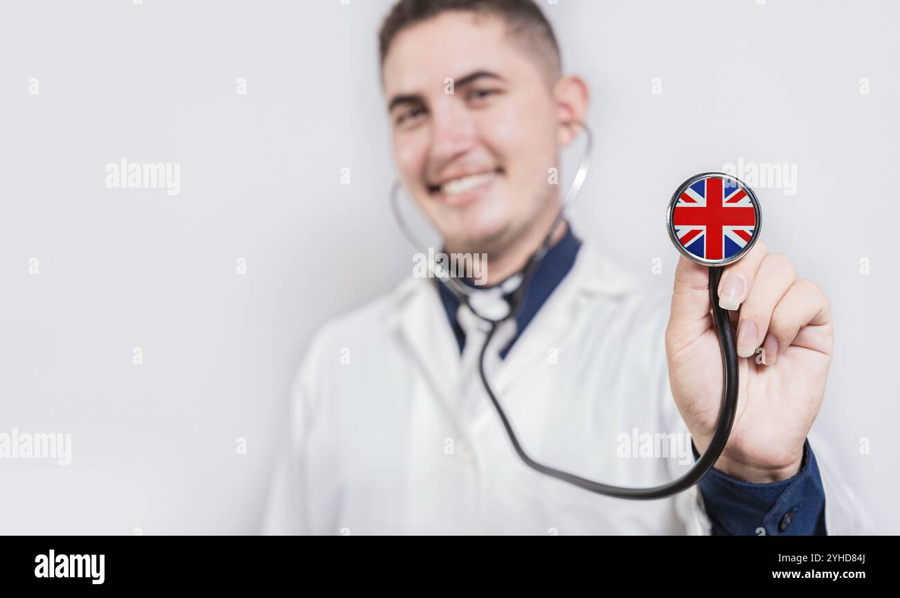 UK National Healthcare concept. Smiling doctor showing stethoscope with ...