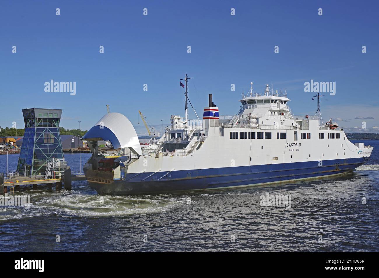 A large ferry docks in the harbour under a blue sky, electric ferry ...