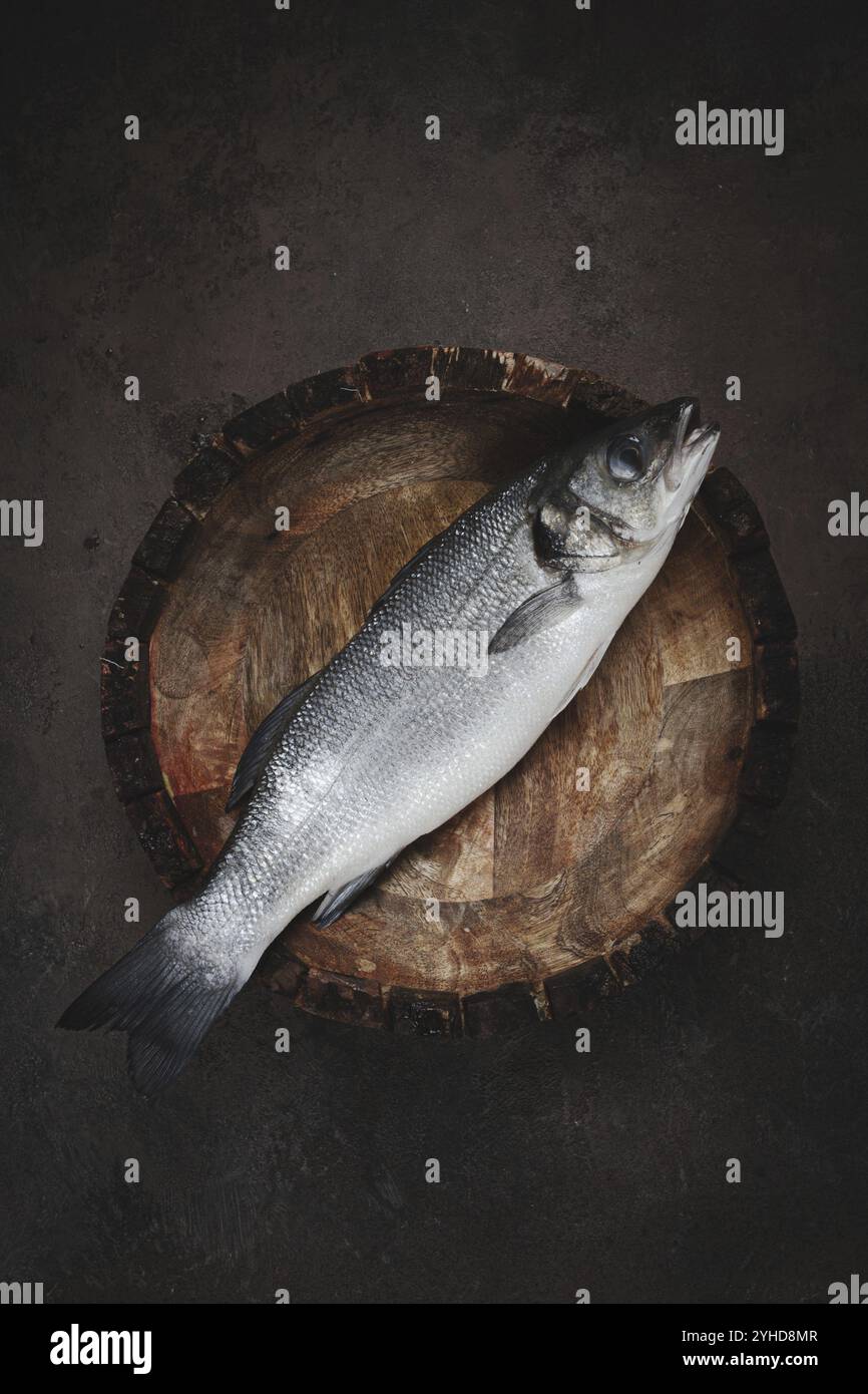 Fresh, raw sea bass fish, in a wooden plate, top view, no people Stock ...