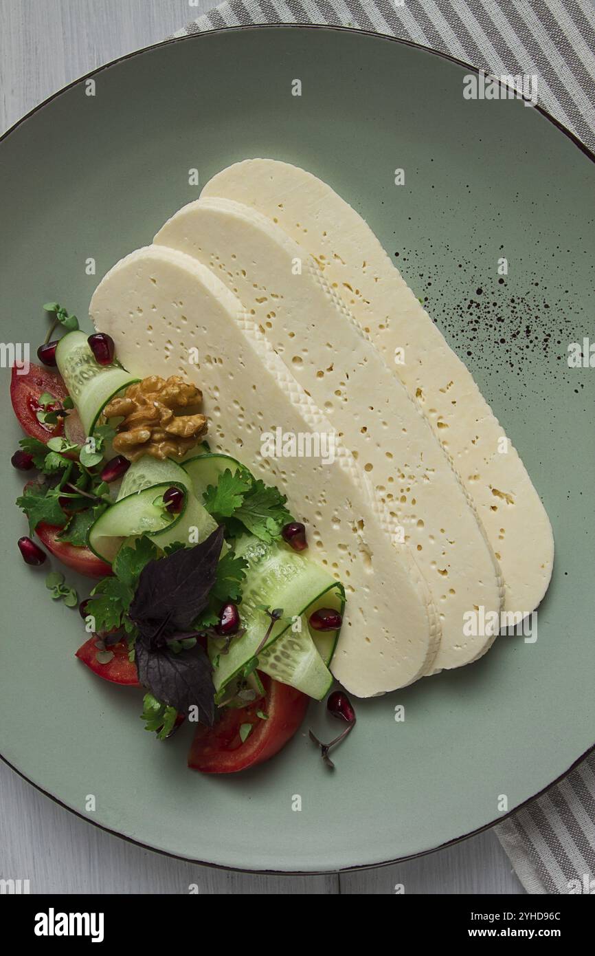 Sliced Imeruli cheese, Georgian cheese, with vegetables, top view, no ...