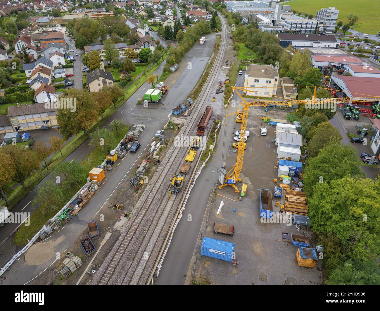 An aerial view of a construction site next to railway tracks with ...
