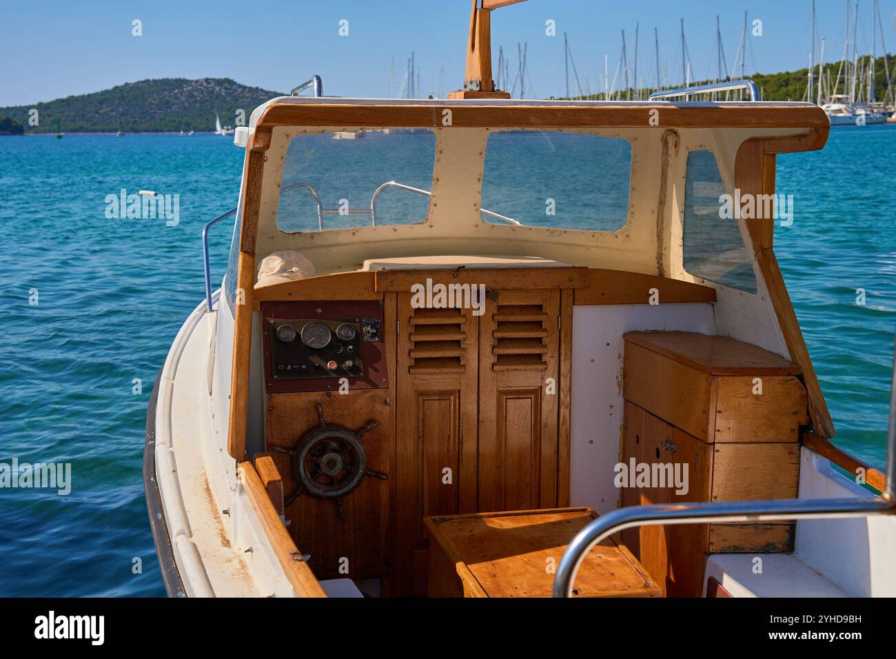 Wooden cockpit of small boat with steering wheel, gauges and cabin ...