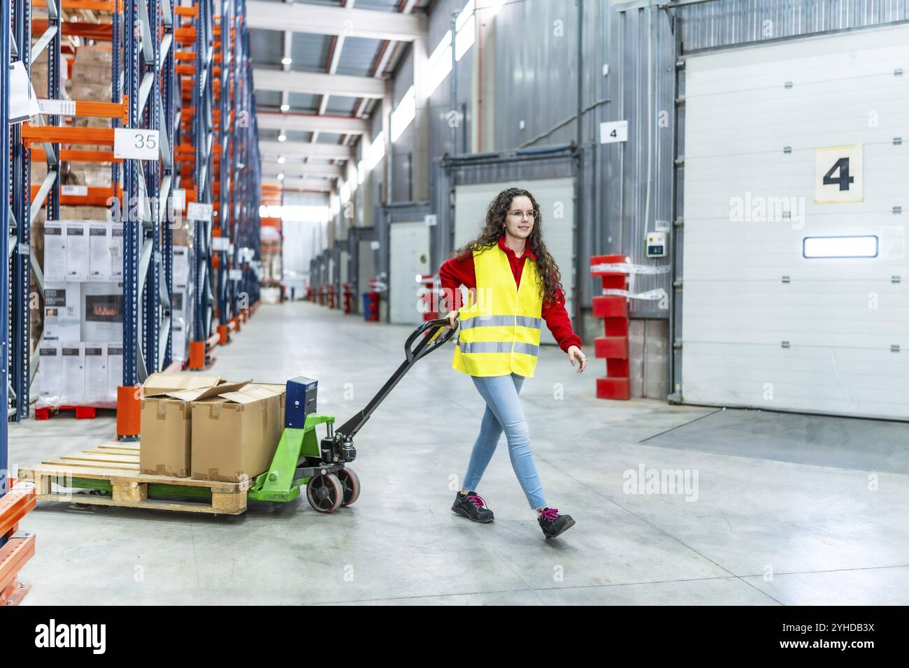 Full length photo of a female caucasian young worker carrying trolley ...