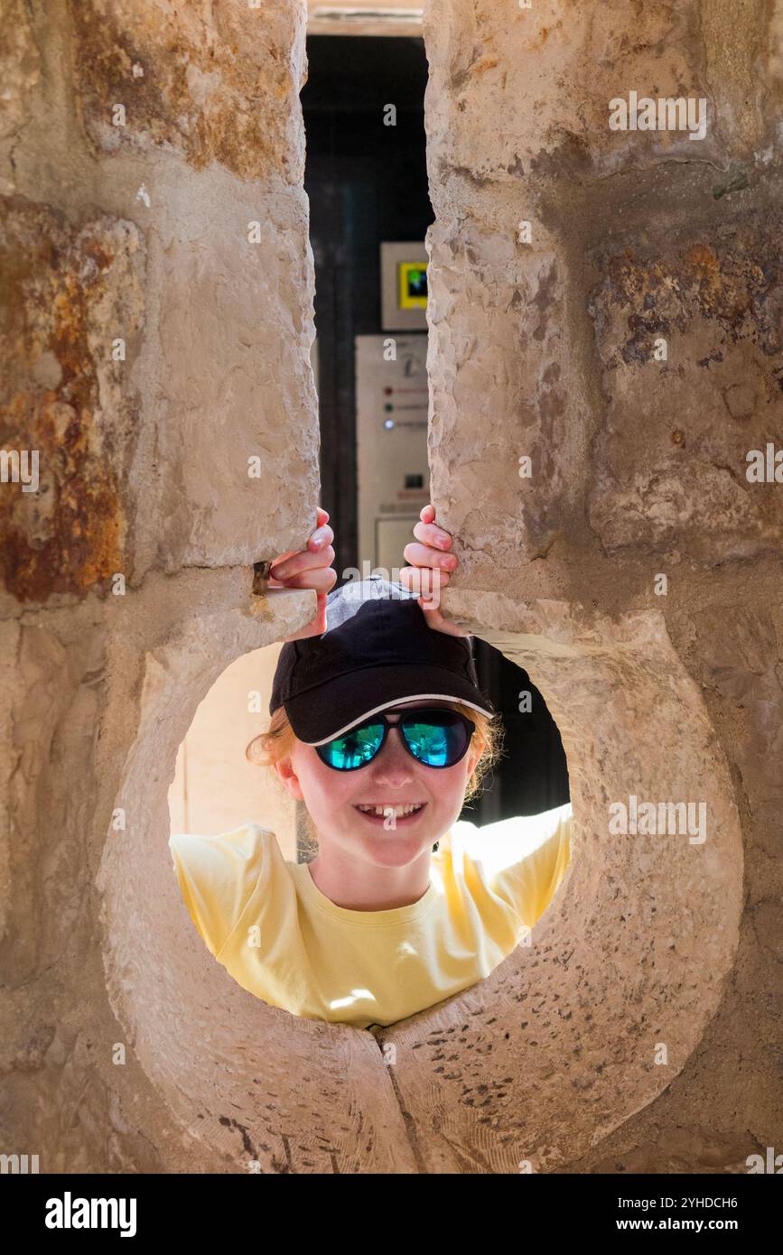 Happy smiling young girl aged 9 years looking through loop hole / arrow ...