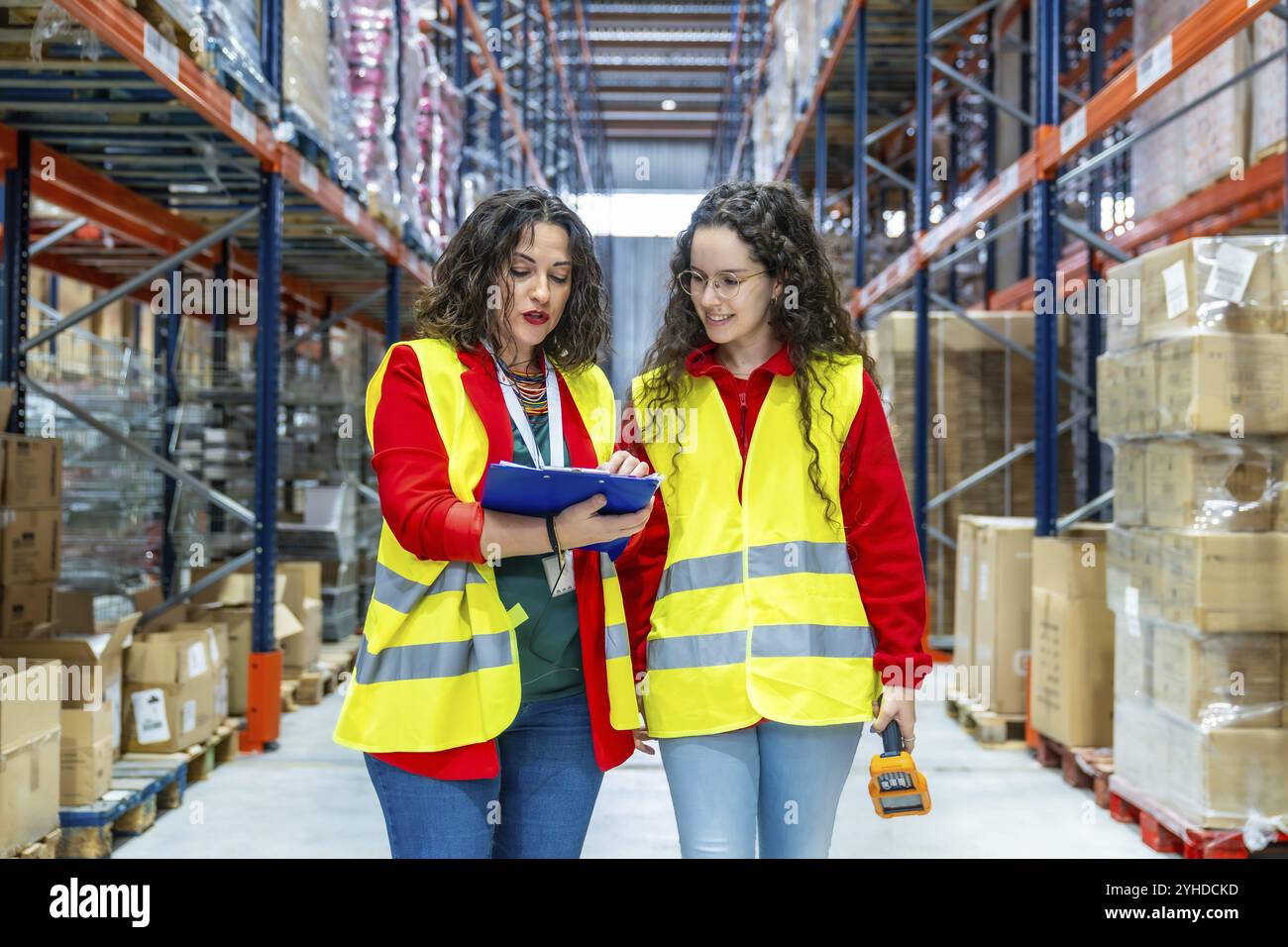 Frontal photo of two female colleagues talking and taking inventory in ...