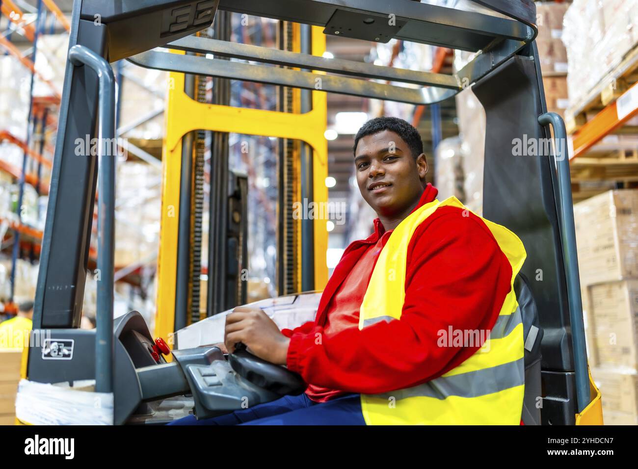 Side view of a happy latin american worker driving forklift in a ...