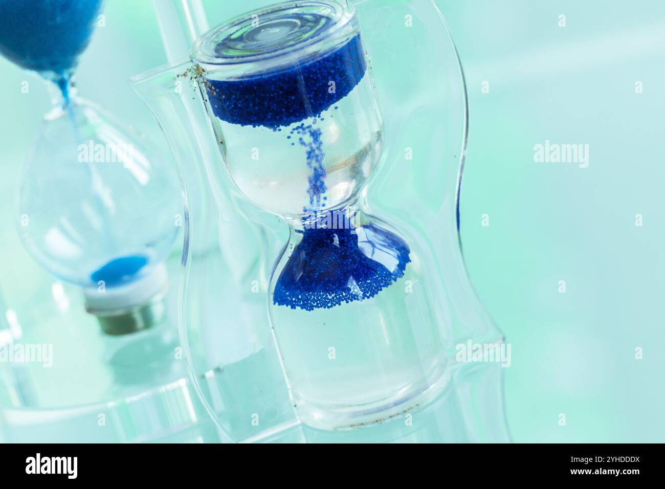 Time passing. Blue hourglass Stock Photo - Alamy