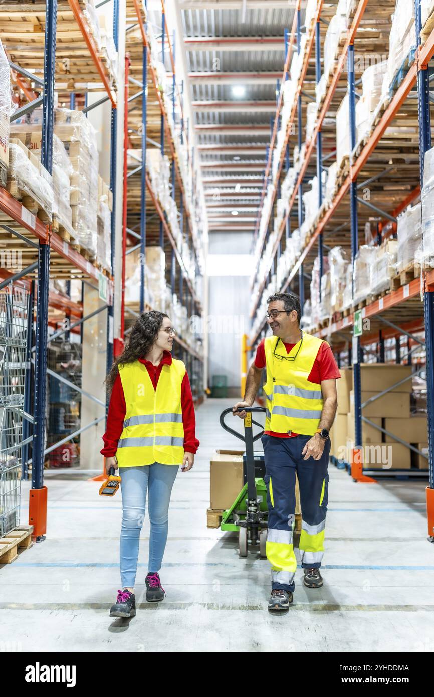 Vertical photo of two coworkers of storage warehouse talking while ...
