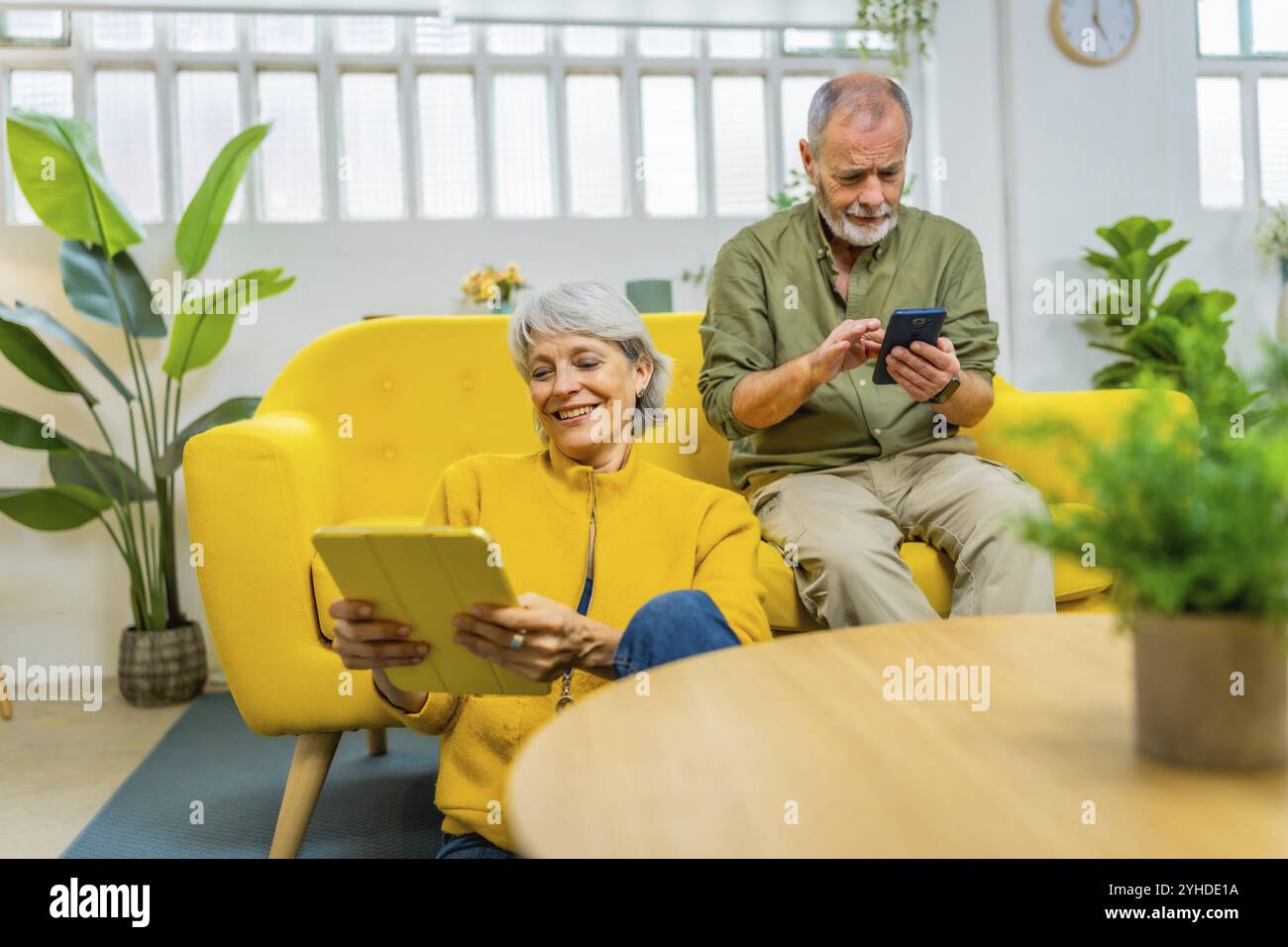 Senior couple using diverse devices and technology together at home ...