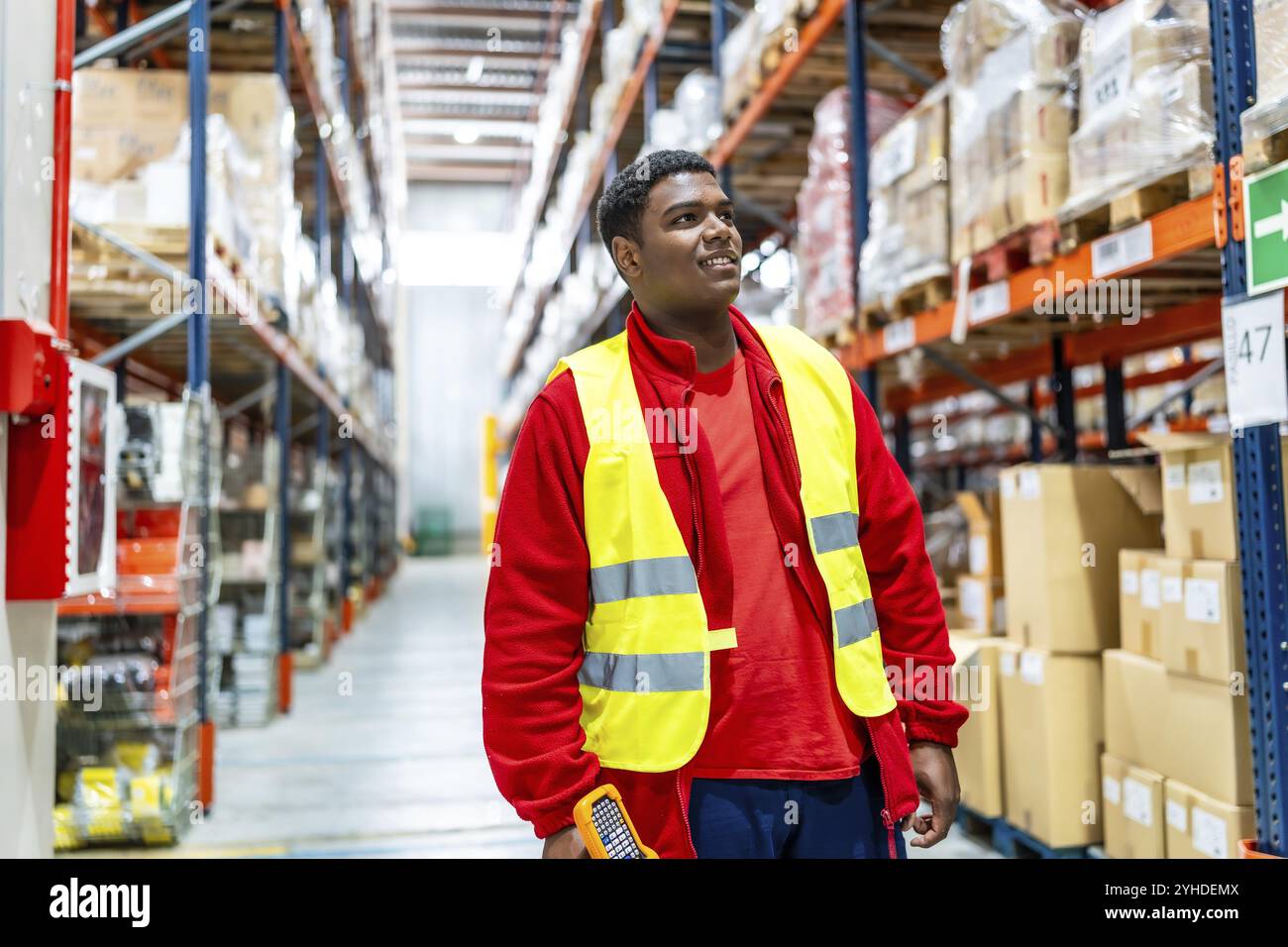 Latin male warehouse worker carrying scan to scan cargo Stock Photo - Alamy