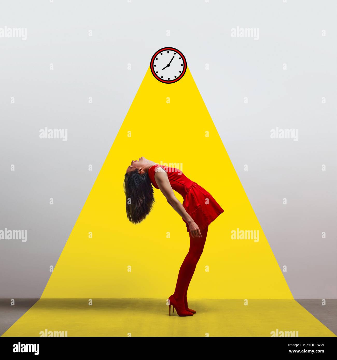 Woman in red dress leaning backward dramatically under yellow spotlight ...