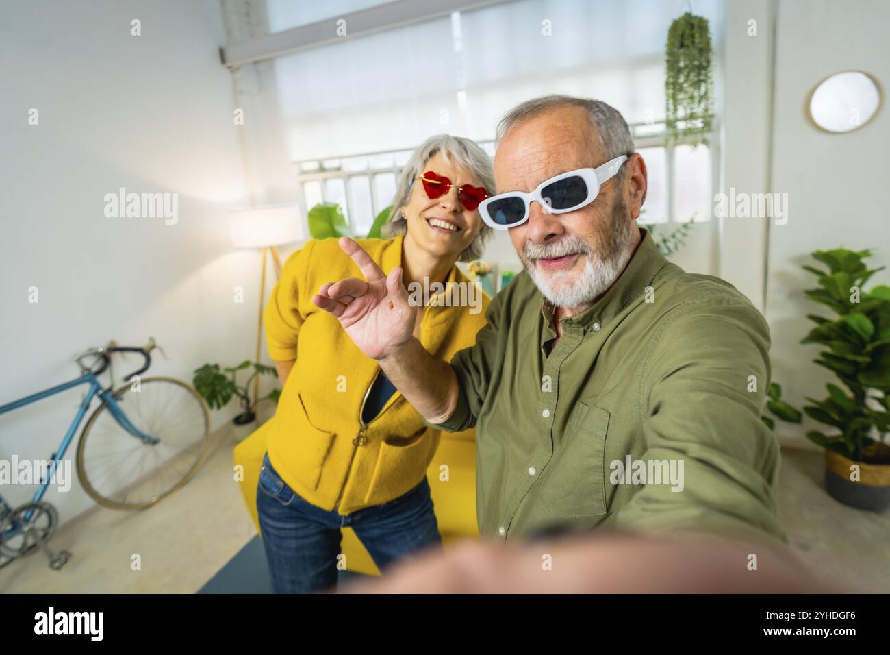 Modern senior couple taking a selfie while having fun together wearing ...