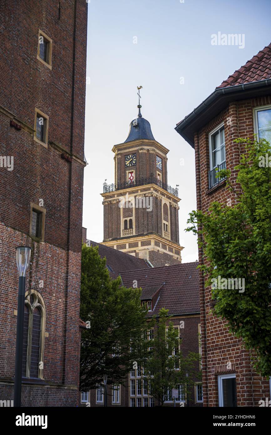 Church tower between brick houses in an architectural setting under a ...