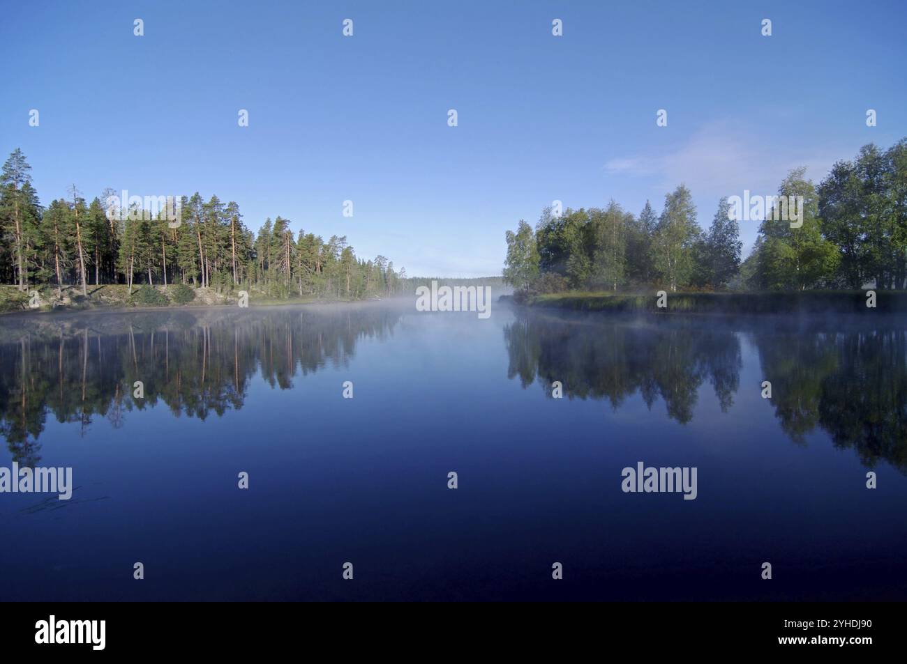Early sunny morning on the river. Remains of fog spread over the ...