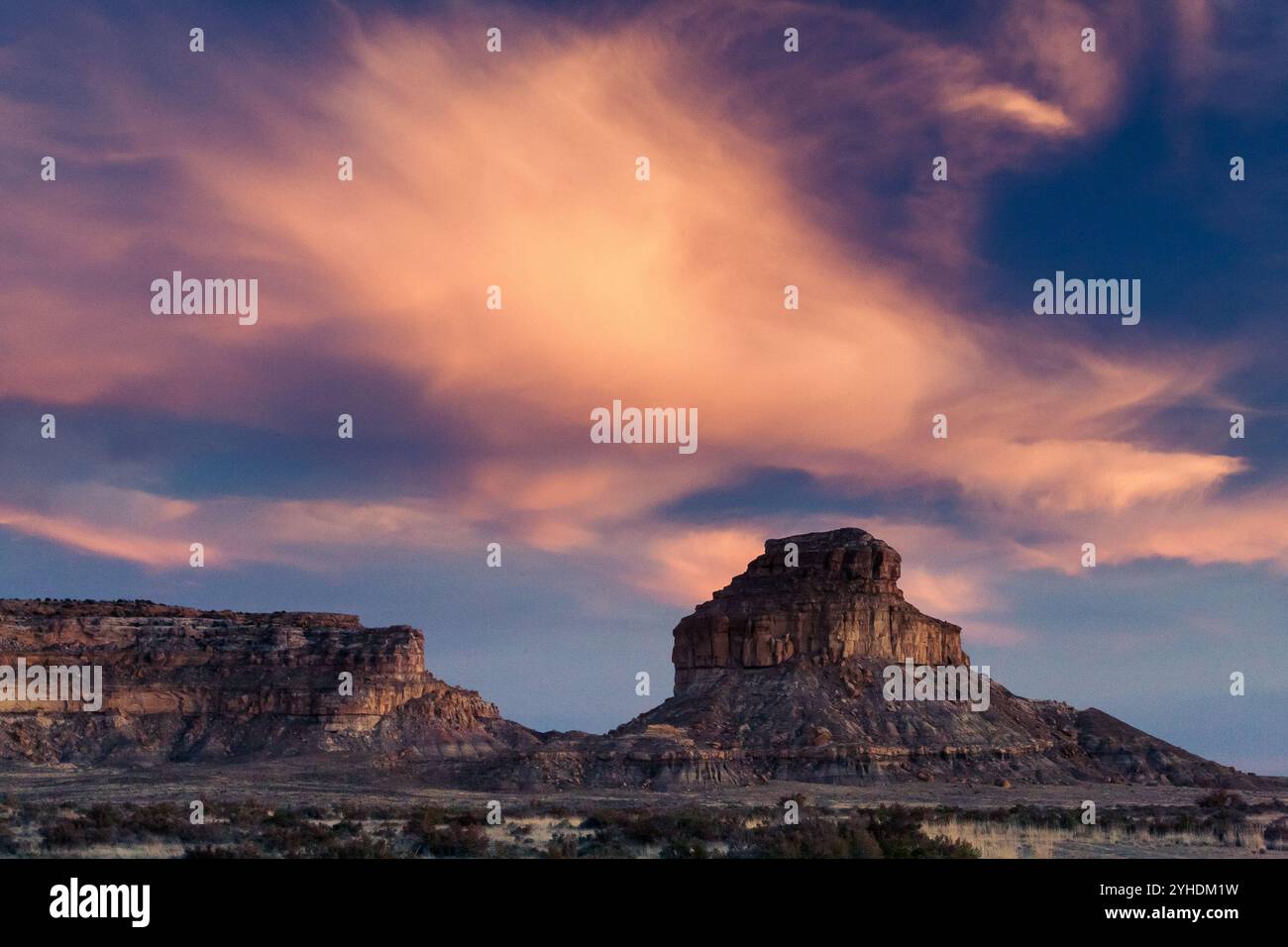 Sunset casts a pink glow on clouds above Fajada Butte and the Fajada ...