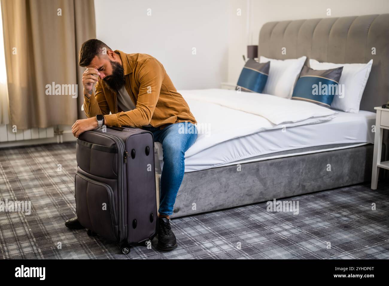 Tourist arrived in hotel room with her suitcase. He is tired of travel ...