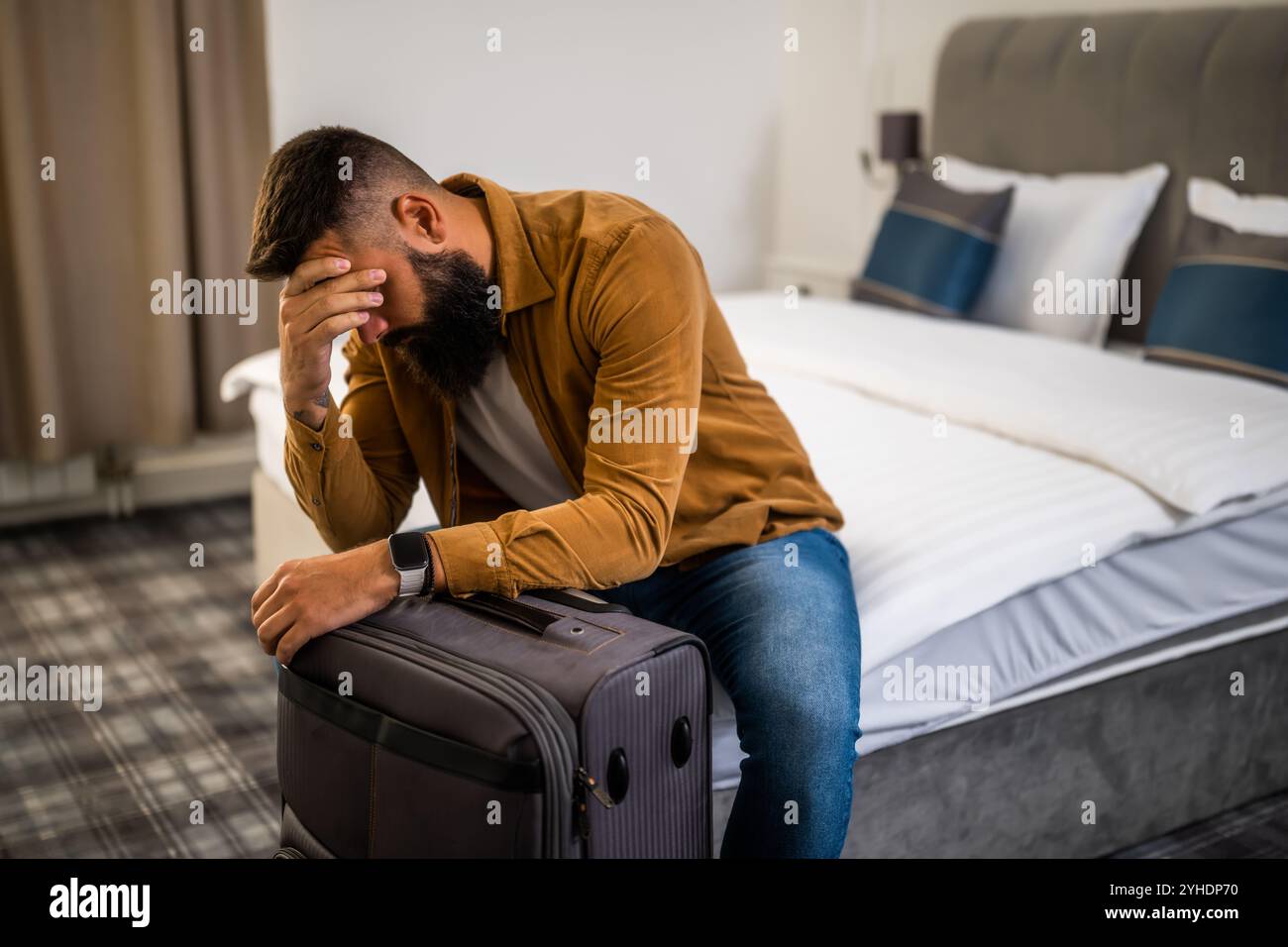 Tourist arrived in hotel room with her suitcase. He is tired of travel ...