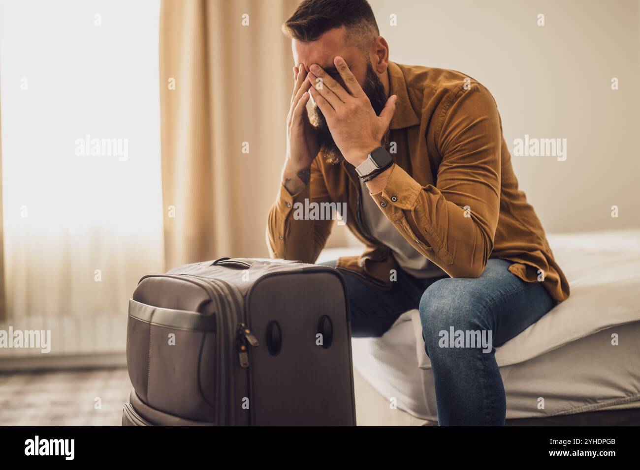 Tourist arrived in hotel room with her suitcase. He is tired of travel ...