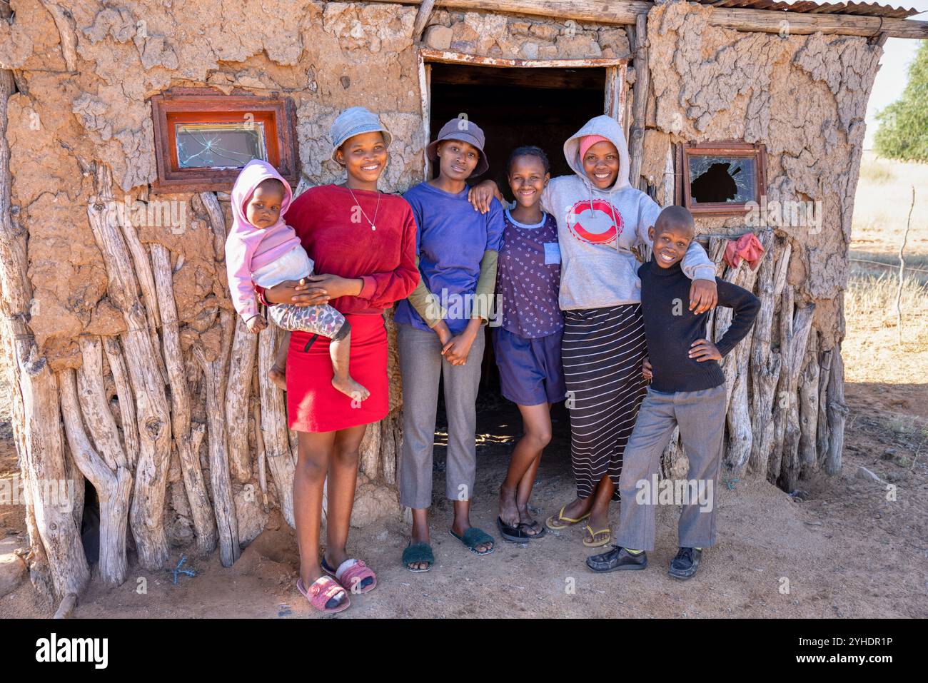 african village, happy large family kids and baby, standing in front of ...