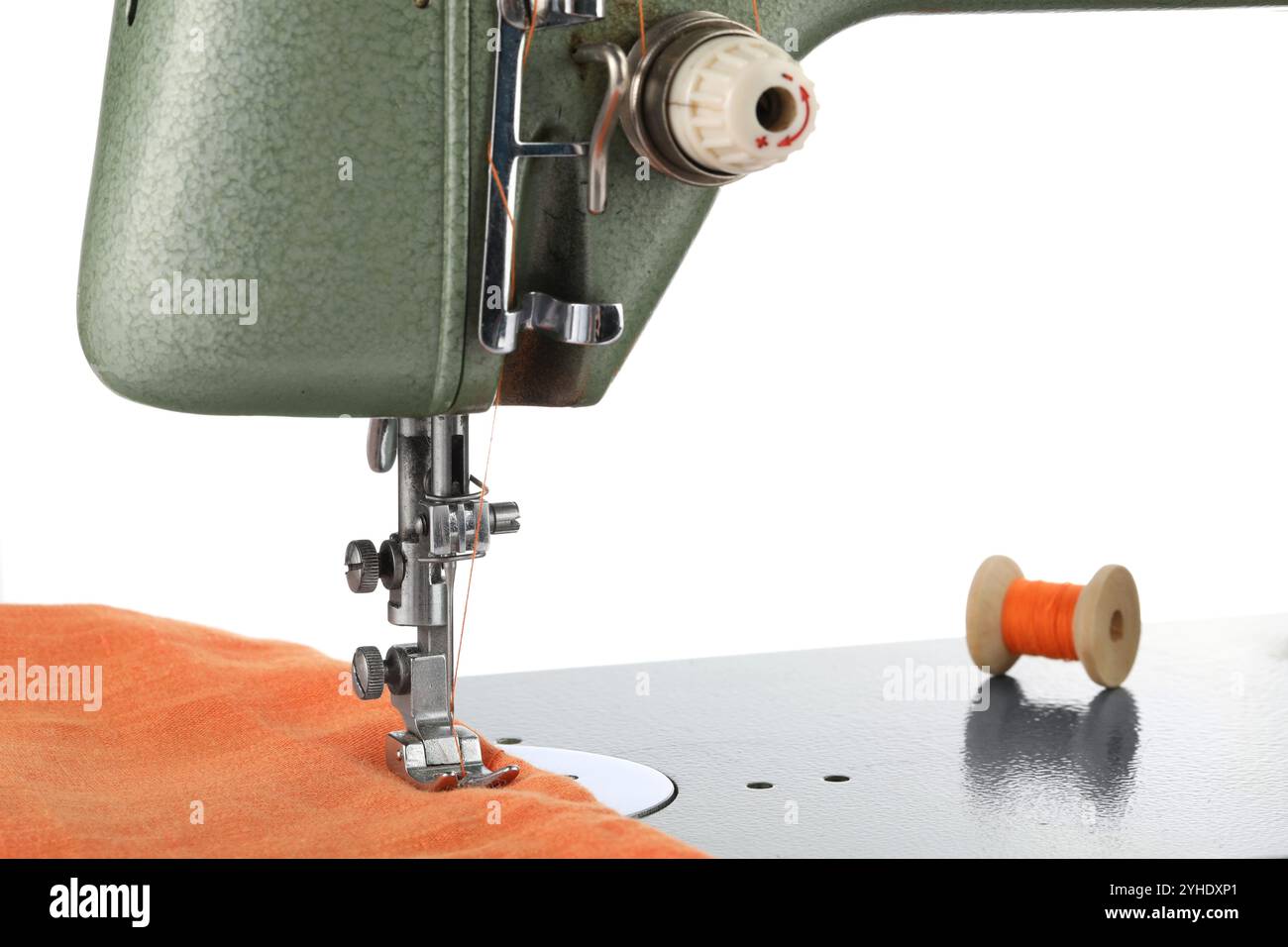 Sewing machine with orange fabric and spool of thread isolated on white ...