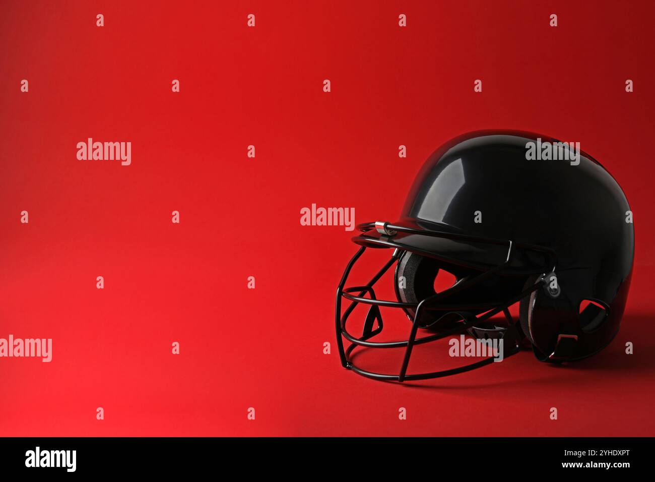 Black baseball helmet on red background, space for text Stock Photo - Alamy