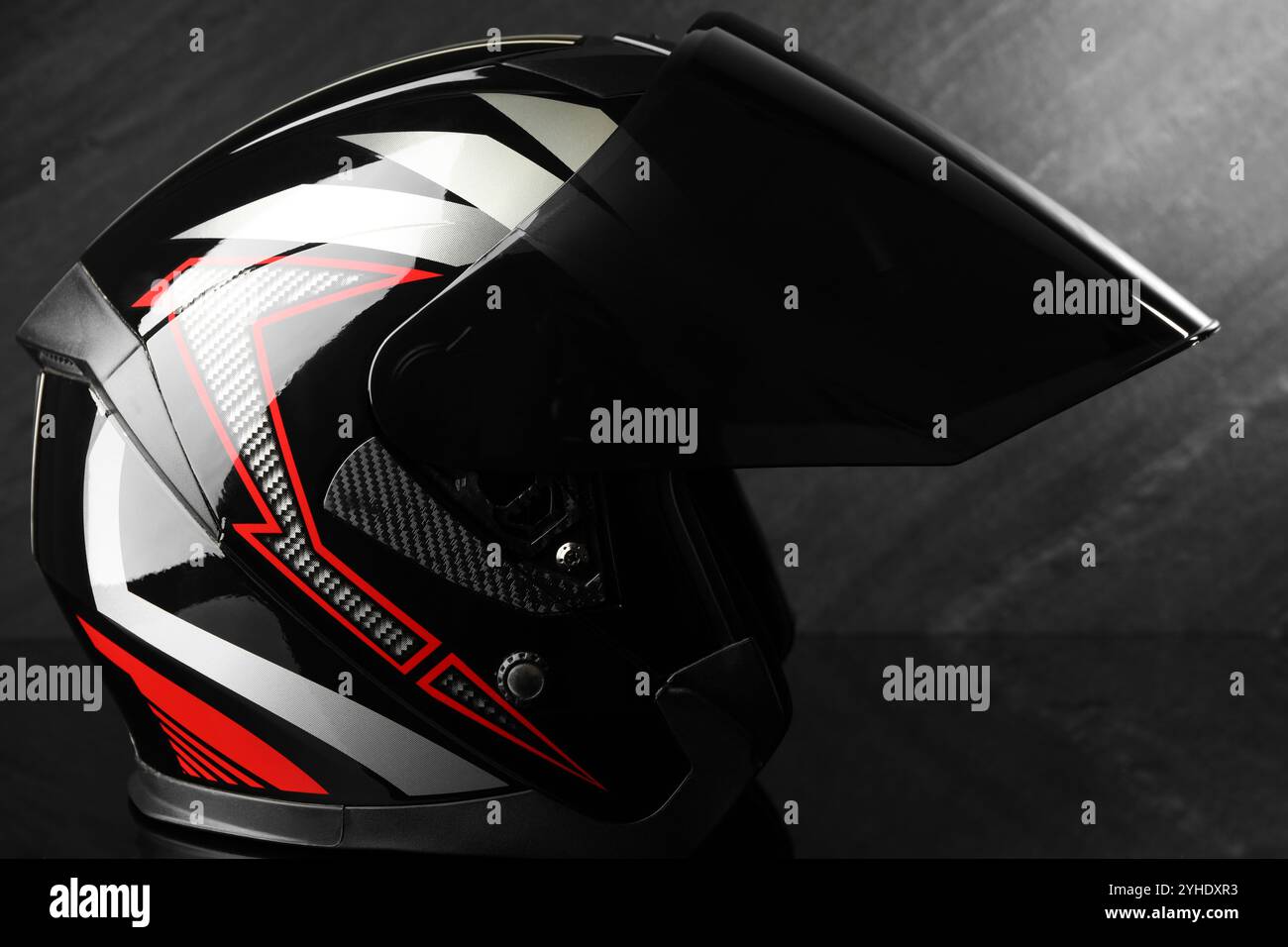 Modern motorcycle helmet with visor on dark gray background, closeup ...