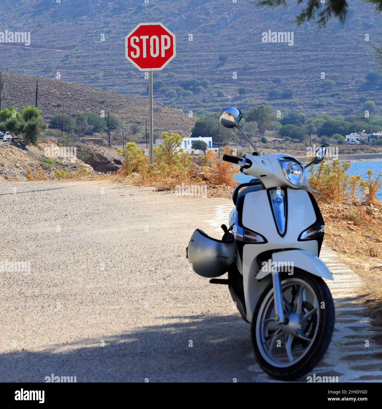 Stop sign and scooter parked in shade Dodecanese Greek islands, Greece ...