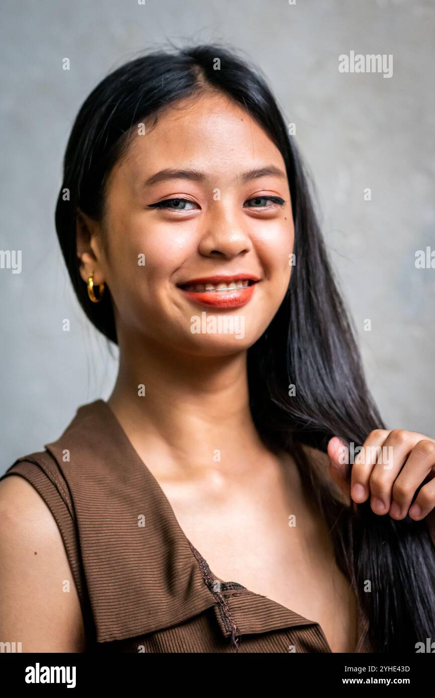 A beautiful young Filipino girl poses and smiles in the Binondo ...
