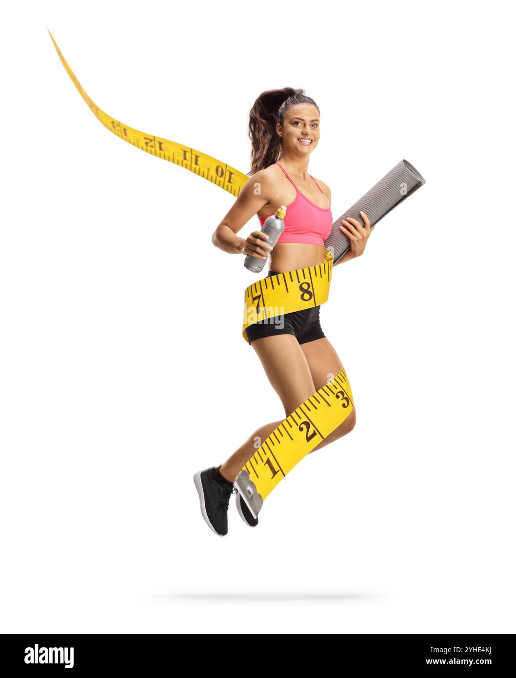 Fit young woman with measure tape around body jumping isolated on white ...