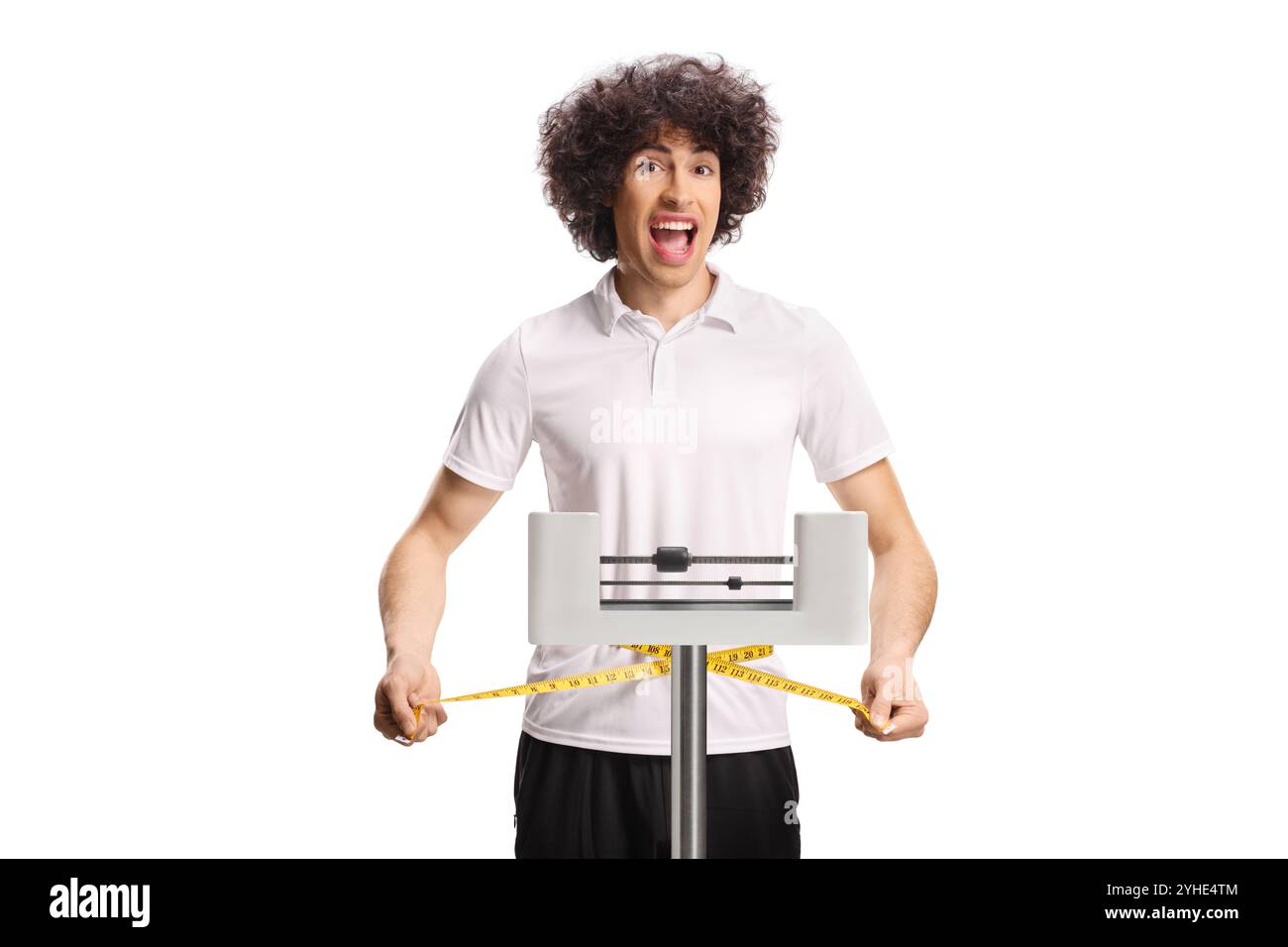 Surprised young man measuring his waist with a tape on a medical scale ...