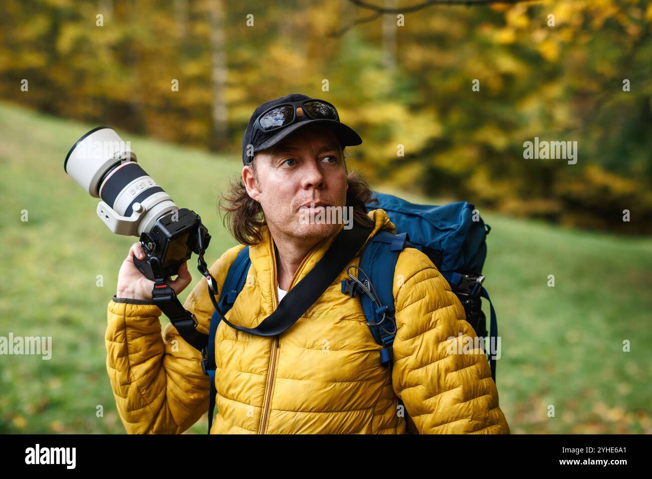 Photographer with camera and backpack hiking in autumn forest. Nature ...