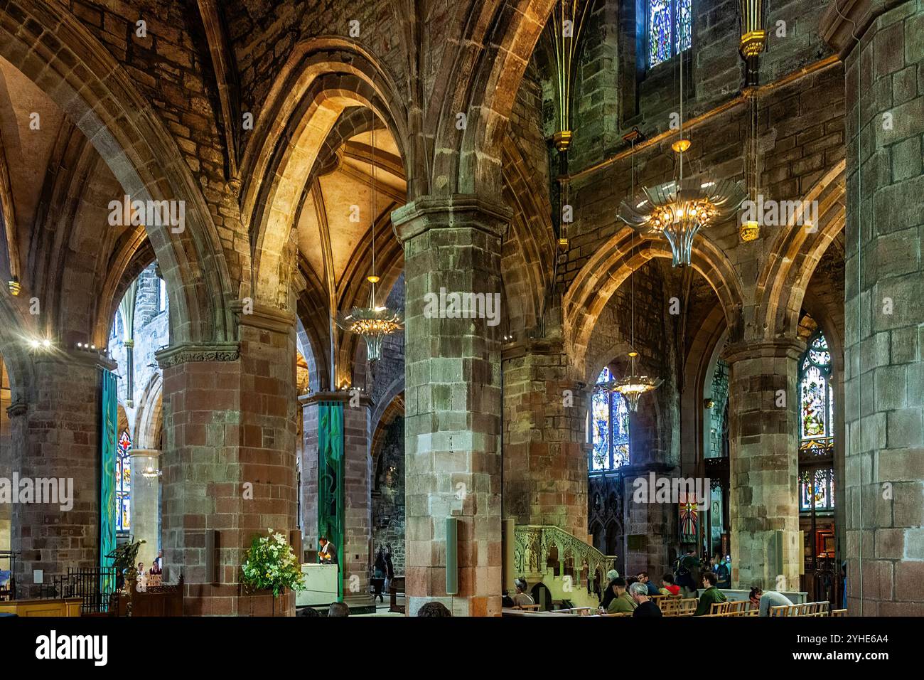 The Gothic interior with stained glass windows and round arches of St ...