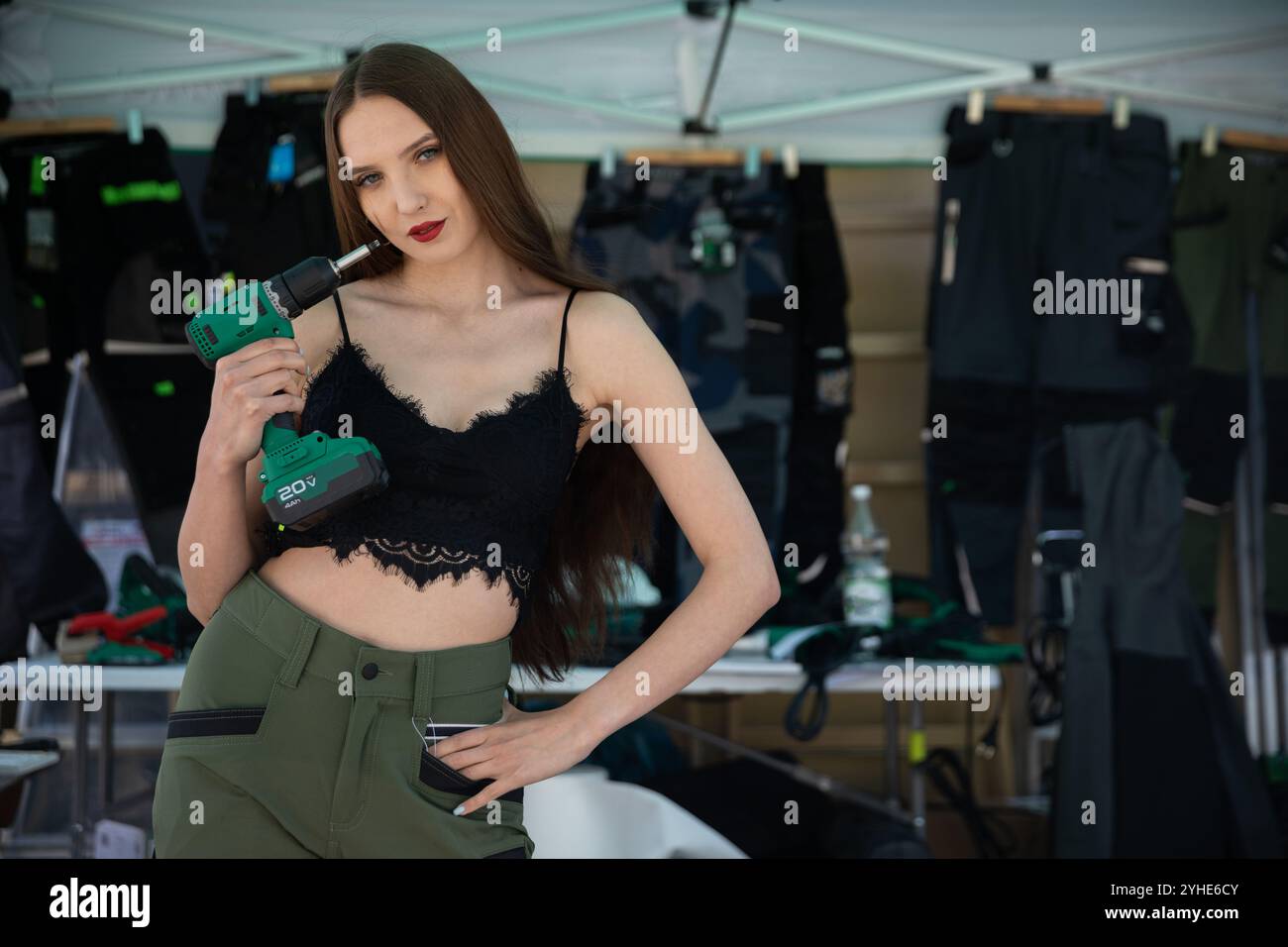 The model is showcasing a power tool while wearing trendy and stylish ...