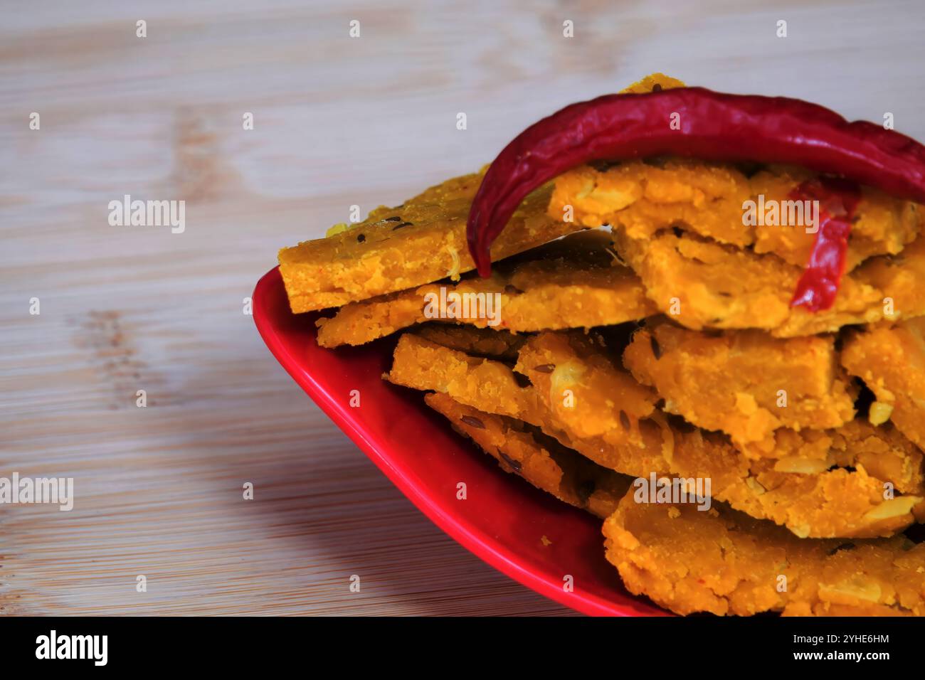 Top view of Gujarati Kathiyawadi Spicy Dhokali Sabji with a red chilli ...