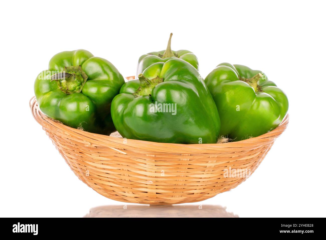 Sweet green capsicum in a straw plate, macro, isolated on white ...
