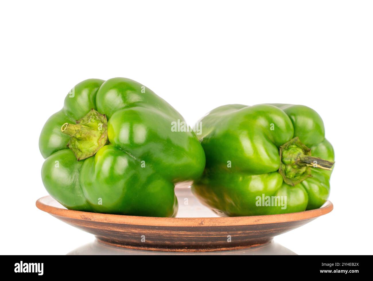 Sweet green capsicum on a clay plate, macro, isolated on white ...