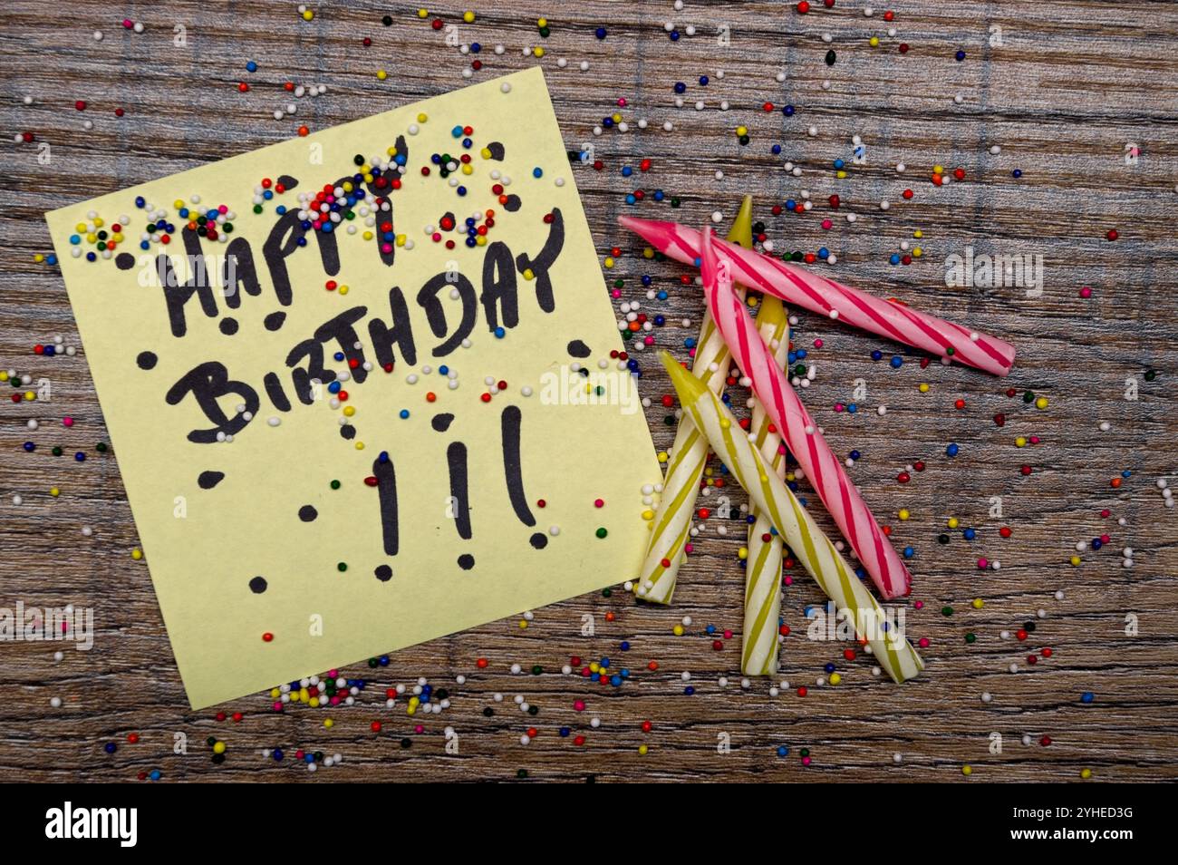 Yellow sticky note with Happy Birthday and candy sprinkles and candles ...