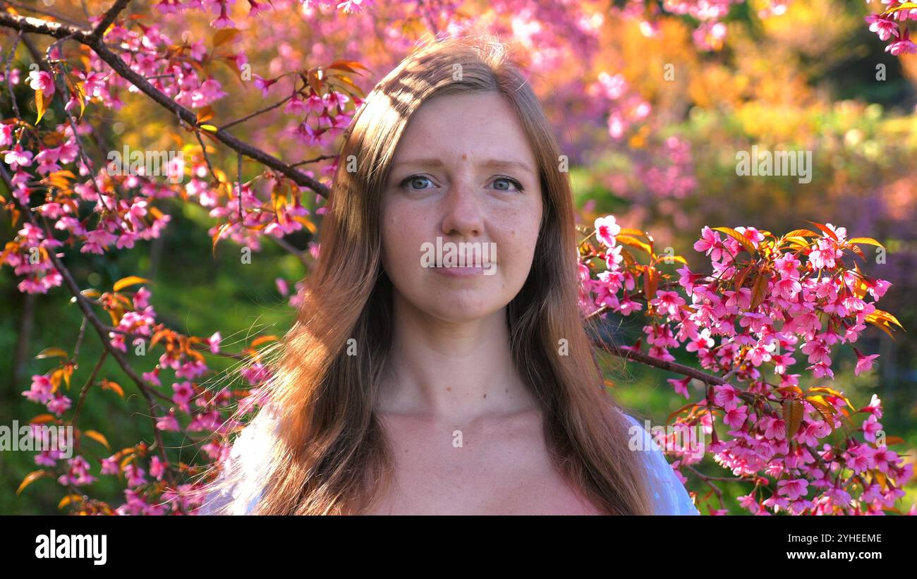 Young woman enjoying beauty of spring blossoms in colorful garden Stock ...