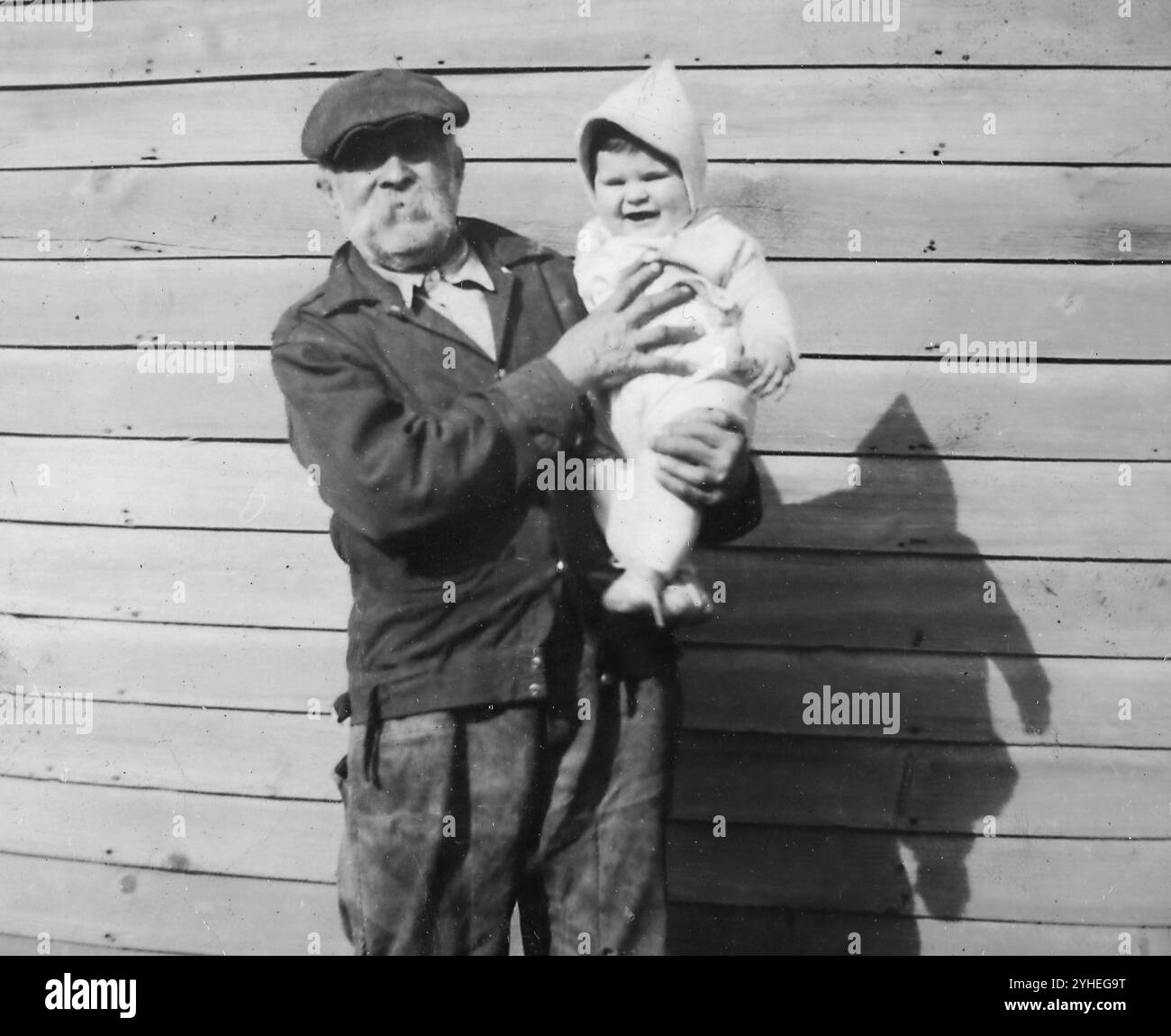 Grandpa seems unhappy holding happy baby for a photo, ca. 1935 Stock ...