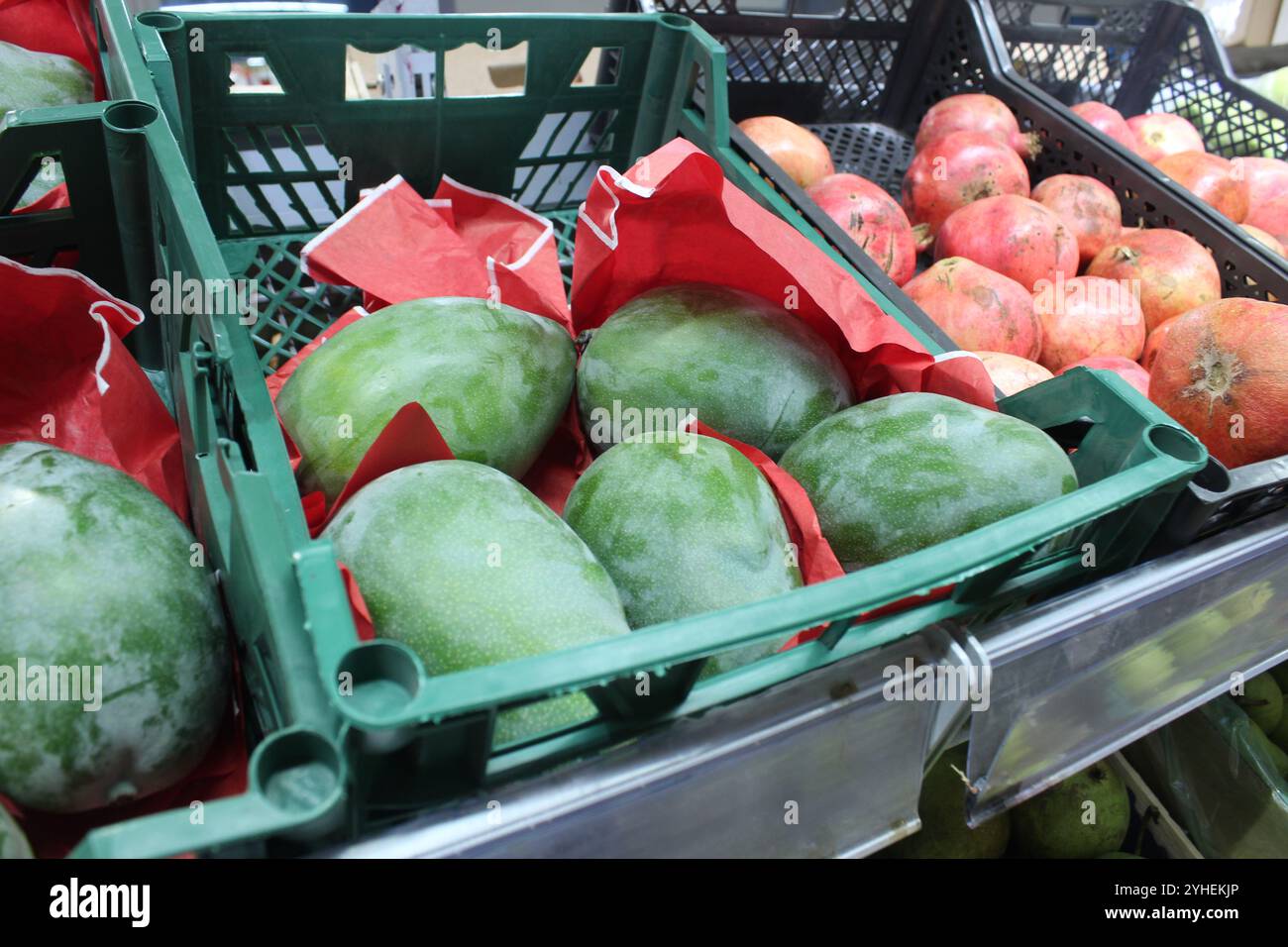 green mango in a plastic box in a store. Fruit display in the store ...