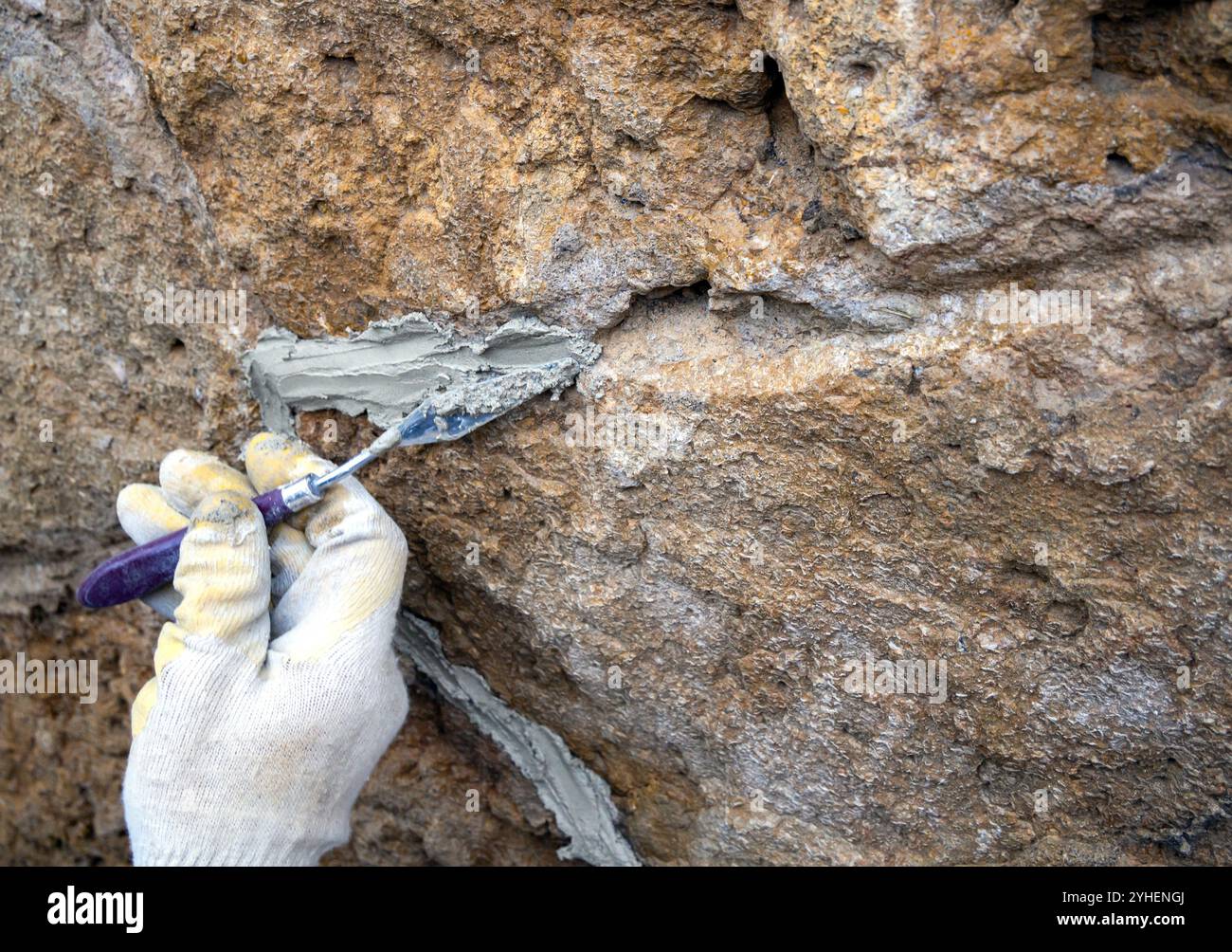 Covering the seam between masonry stones with mortar Stock Photo - Alamy