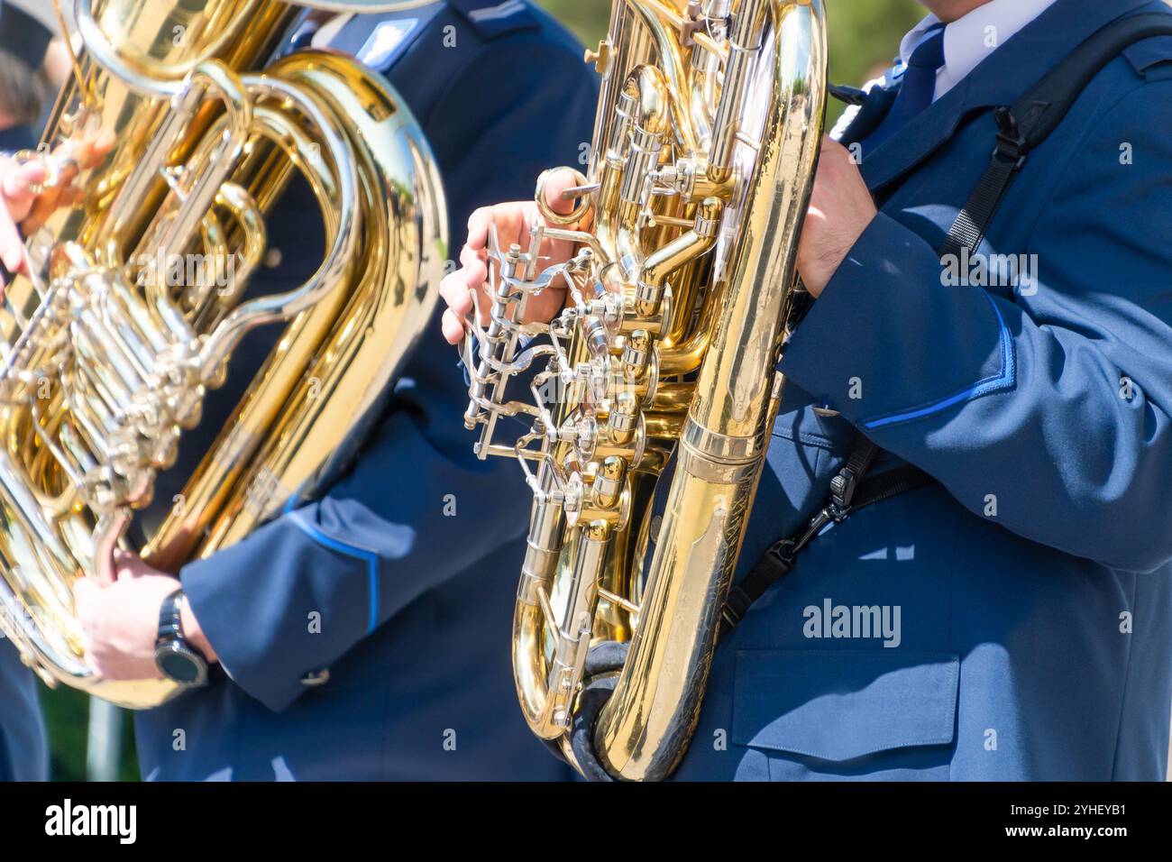 Close-up of brass band musicians playing tubas during a performance ...
