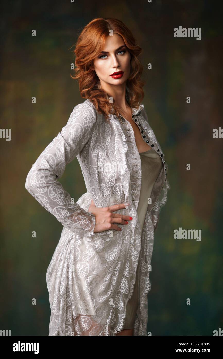 A sophisticated fashion model girl with lush red hair with fine curls ...