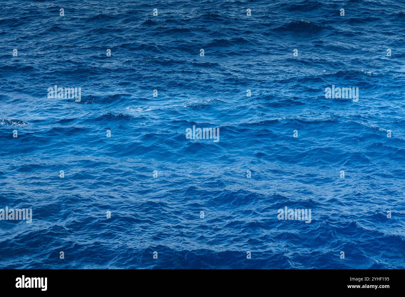 The sun reflects off the deep blue ocean, creating a mesmerizing play ...