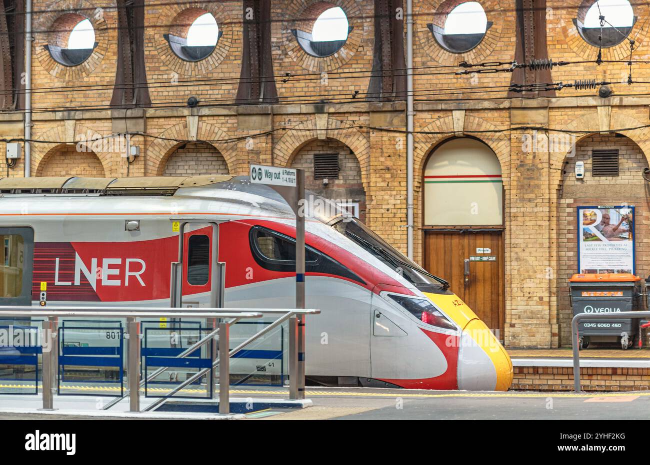 Side view of a modern locomotive stationary at a station platform. The ...