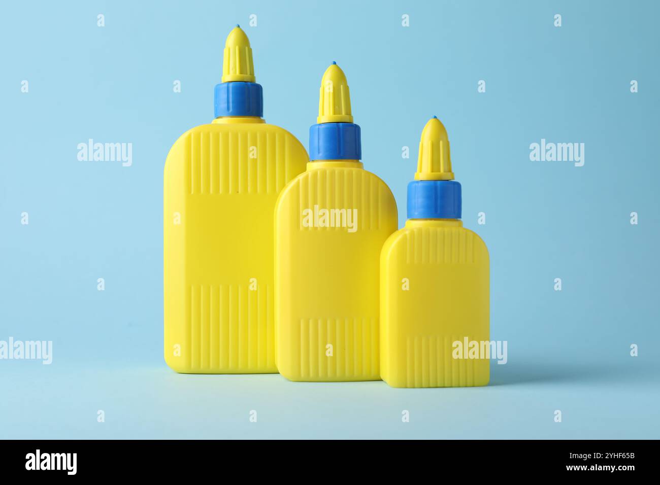 Bottles of glue on light blue background Stock Photo - Alamy