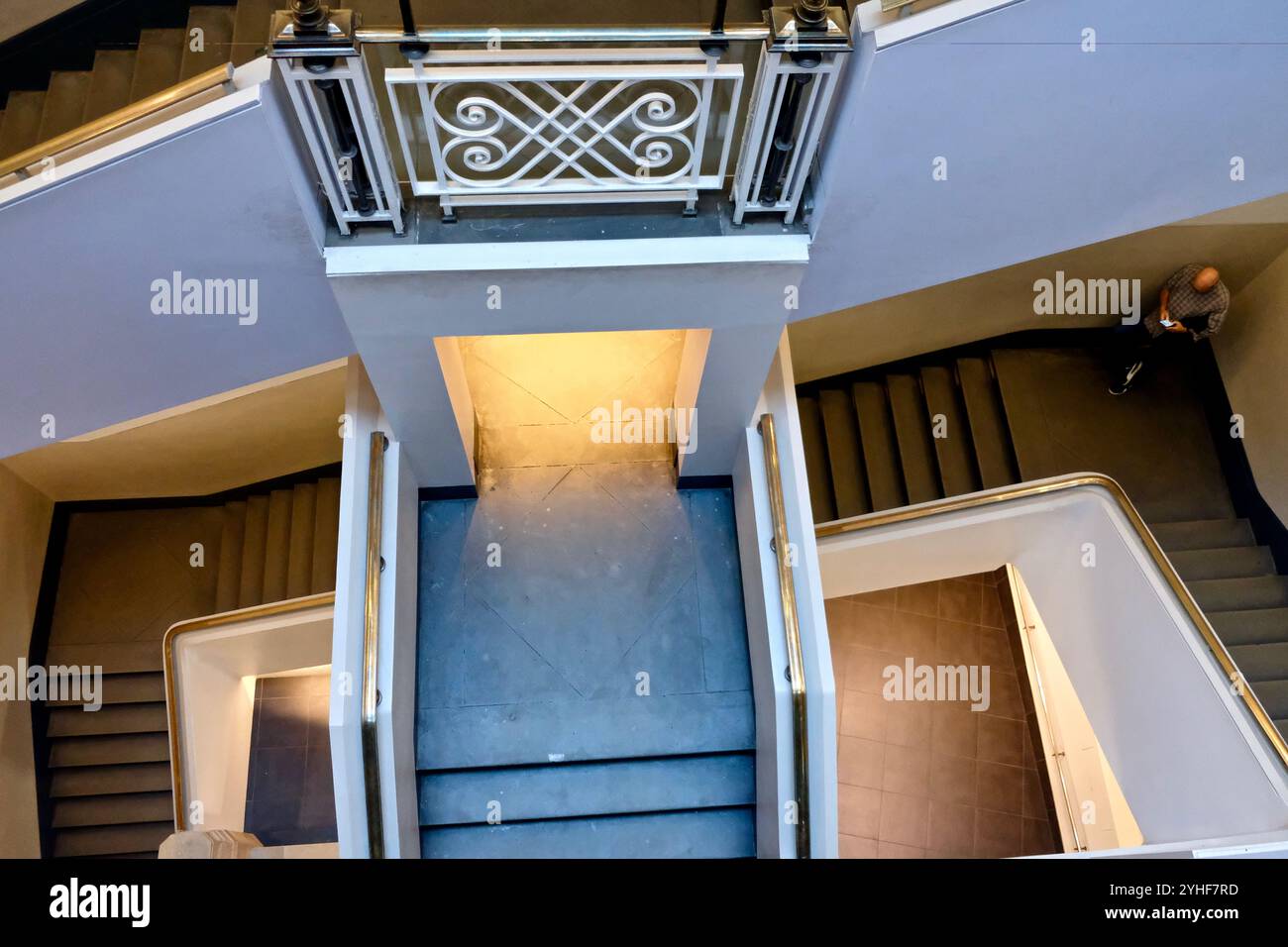 A man using a mobile phone in a quiet corner of a staircase in the ...